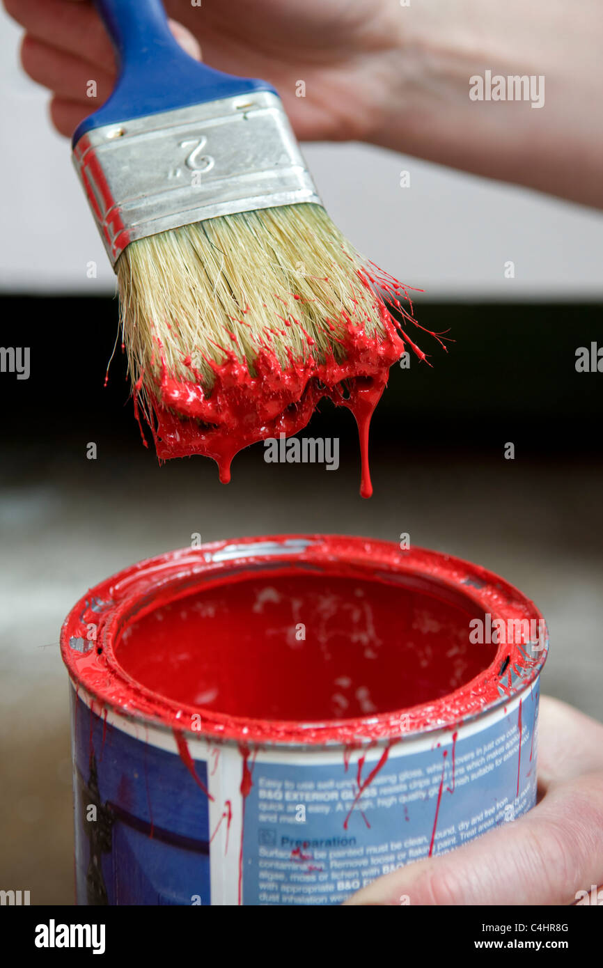 Close up of young Caucasian womans hand holding a dripping paint brush ...