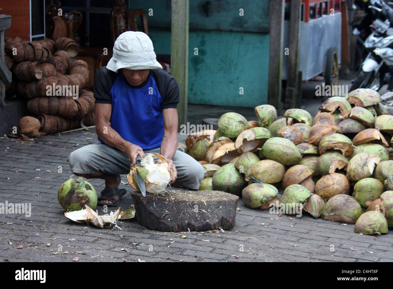 Husking Coconuts in Indonesia Stock Photo - Alamy