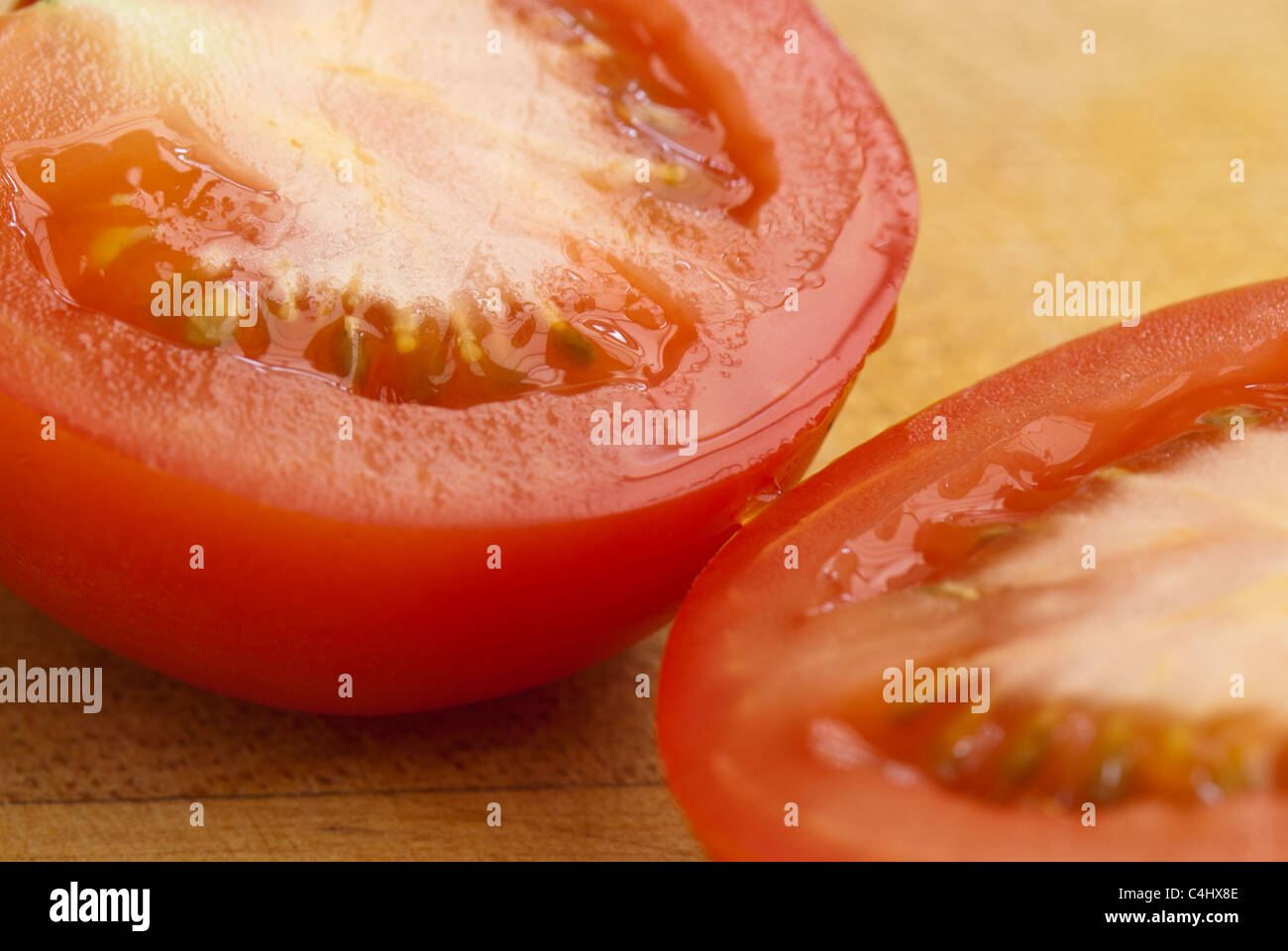 Cross-section of a tomato on a wooden board Stock Photo - Alamy