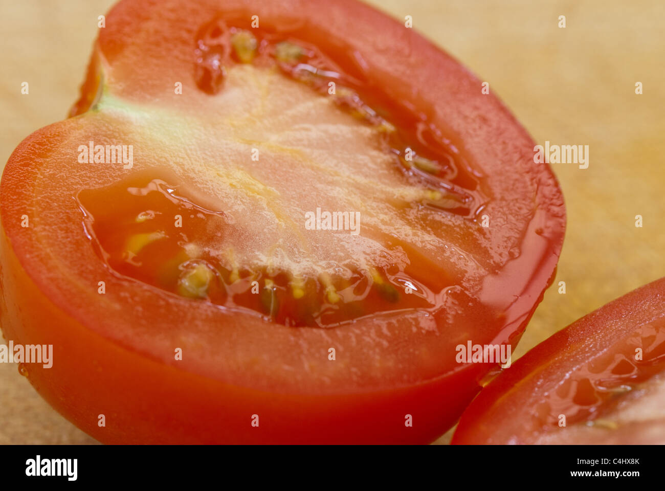 Cross section of a tomato on a wooden board Stock Photo - Alamy