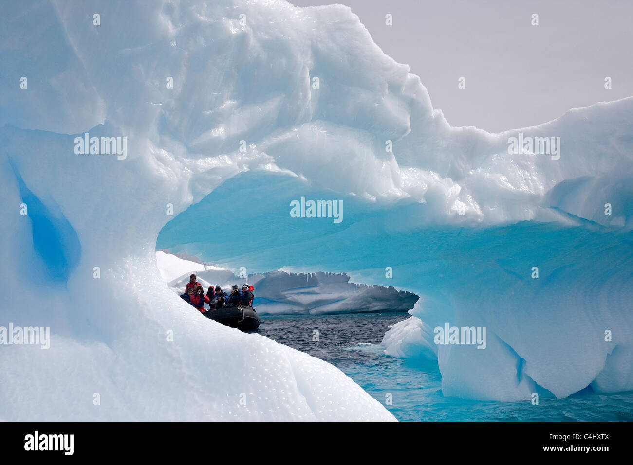 Tourists explorers looking through an iceberg Stock Photo - Alamy