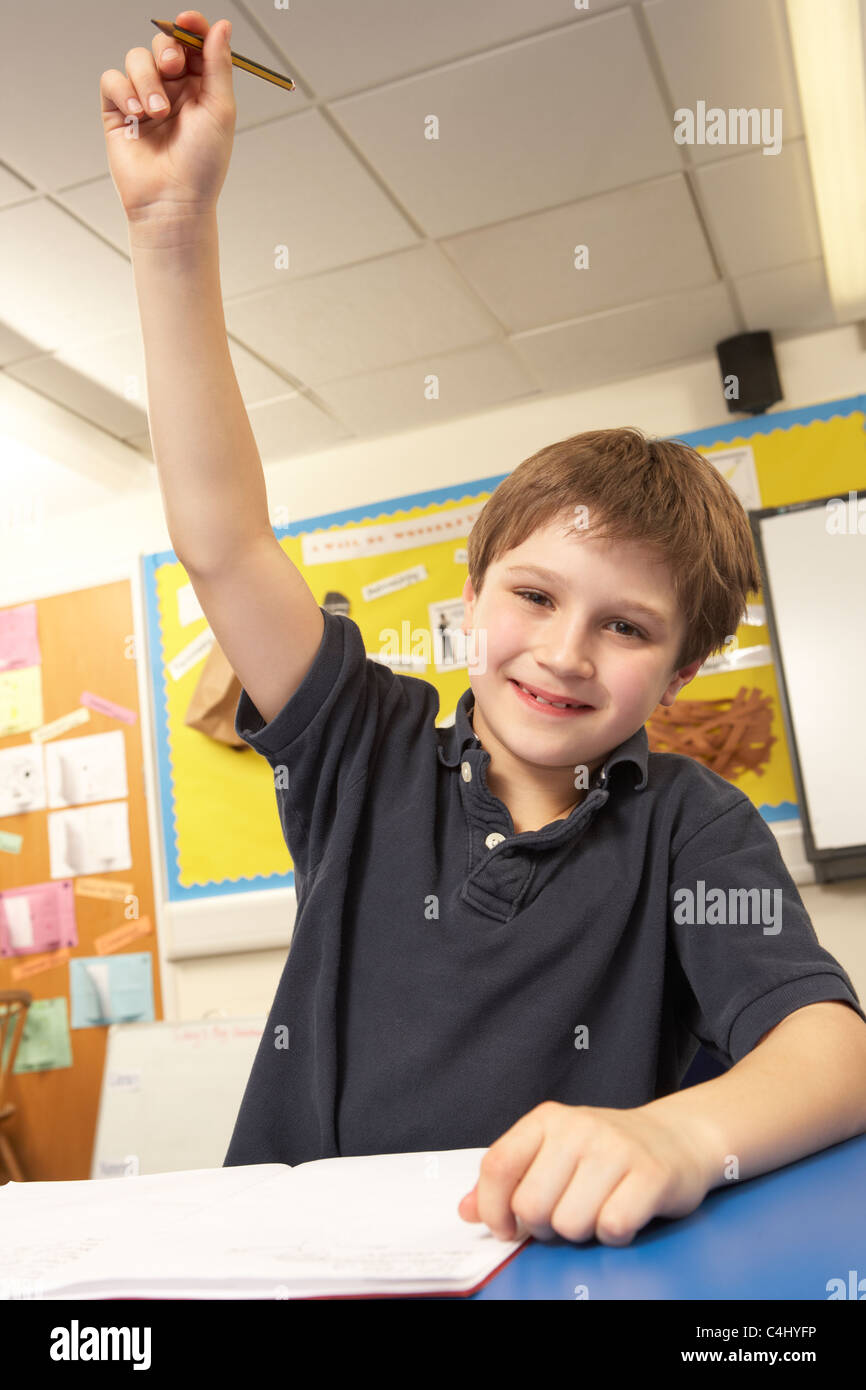 Schoolboy Answering Question In Classroom Stock Photo - Alamy
