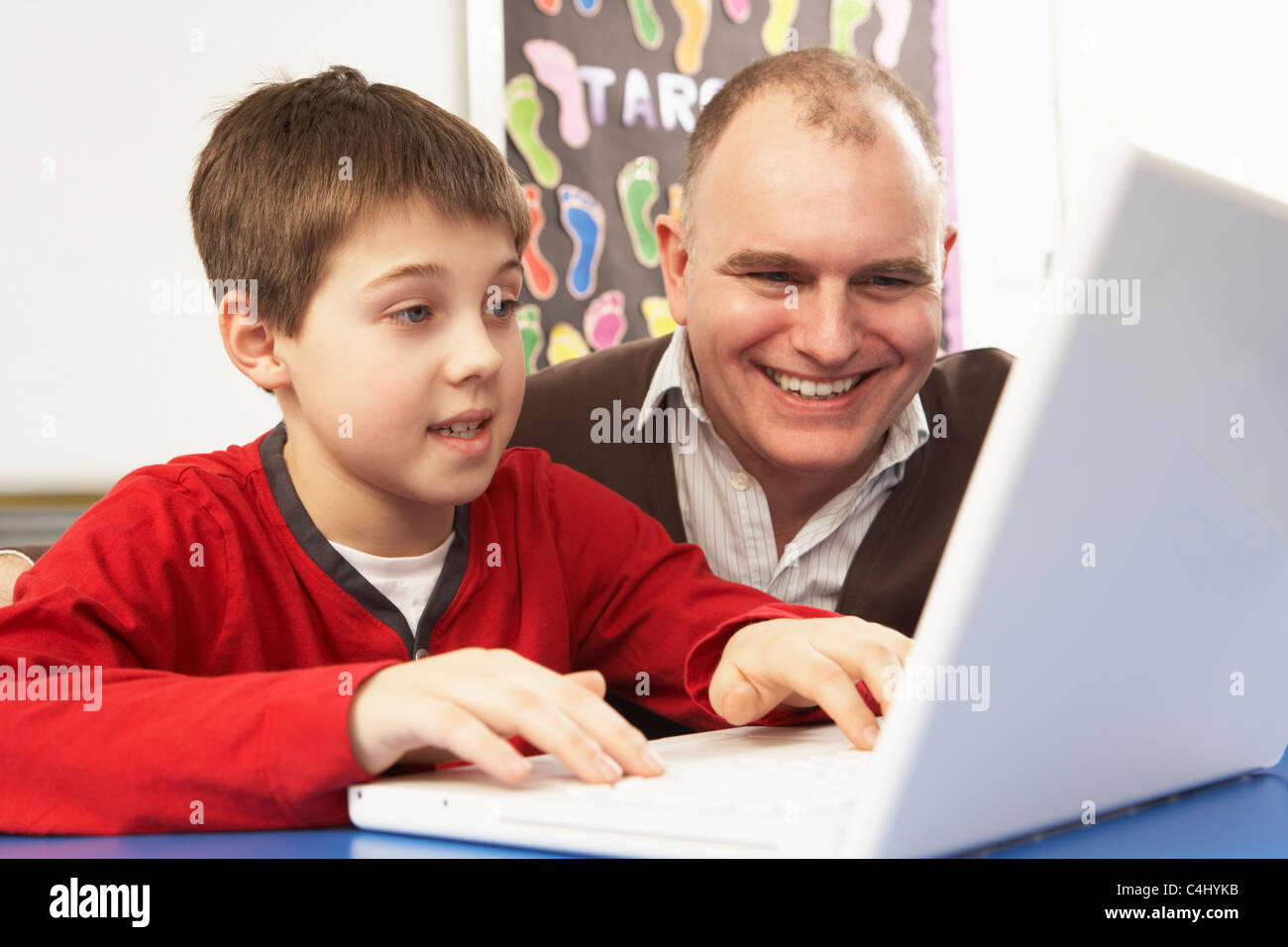 Schoolboy In IT Class Using Computer With Teacher Stock Photo - Alamy