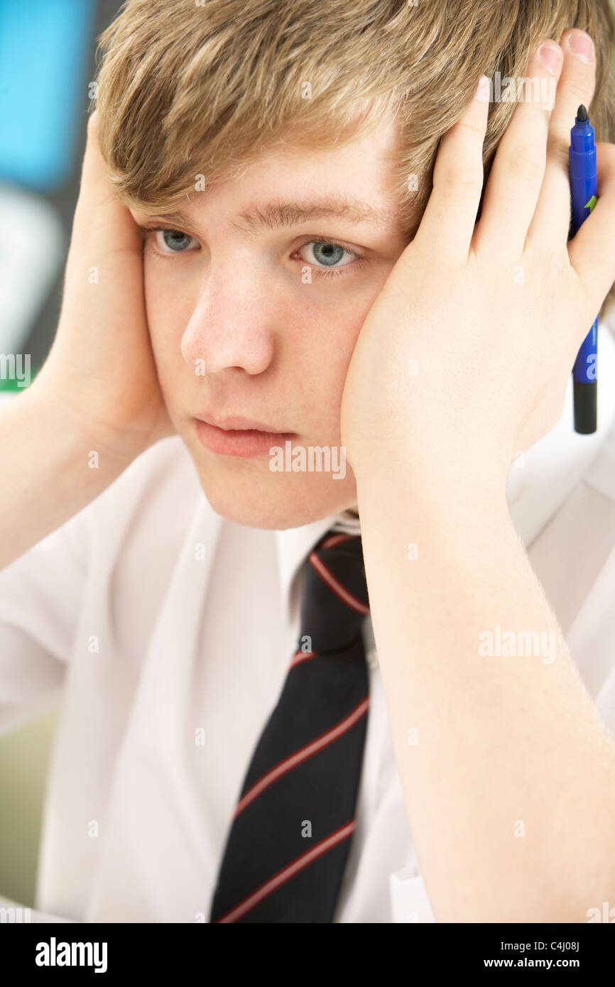 Stressed Male Teenage Student Studying In Classroom Stock Photo - Alamy