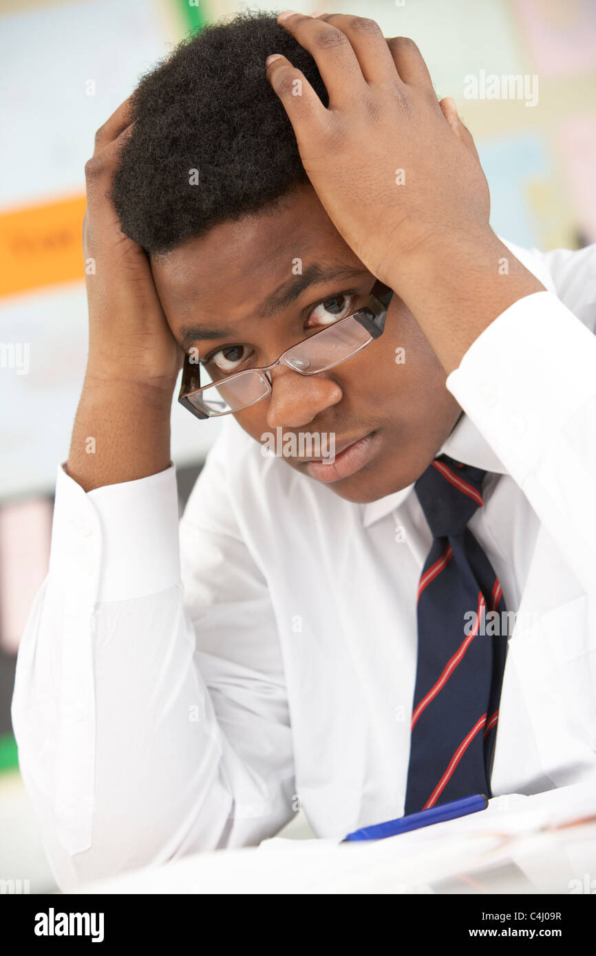 Stressed Male Teenage Student Studying In Classroom Stock Photo - Alamy