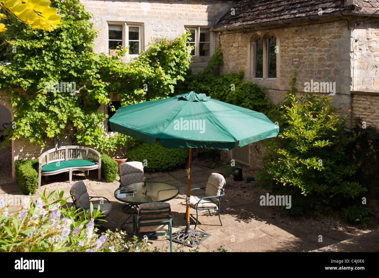 UK gardens. Secluded patio terrace with garden tables and chairs and ...