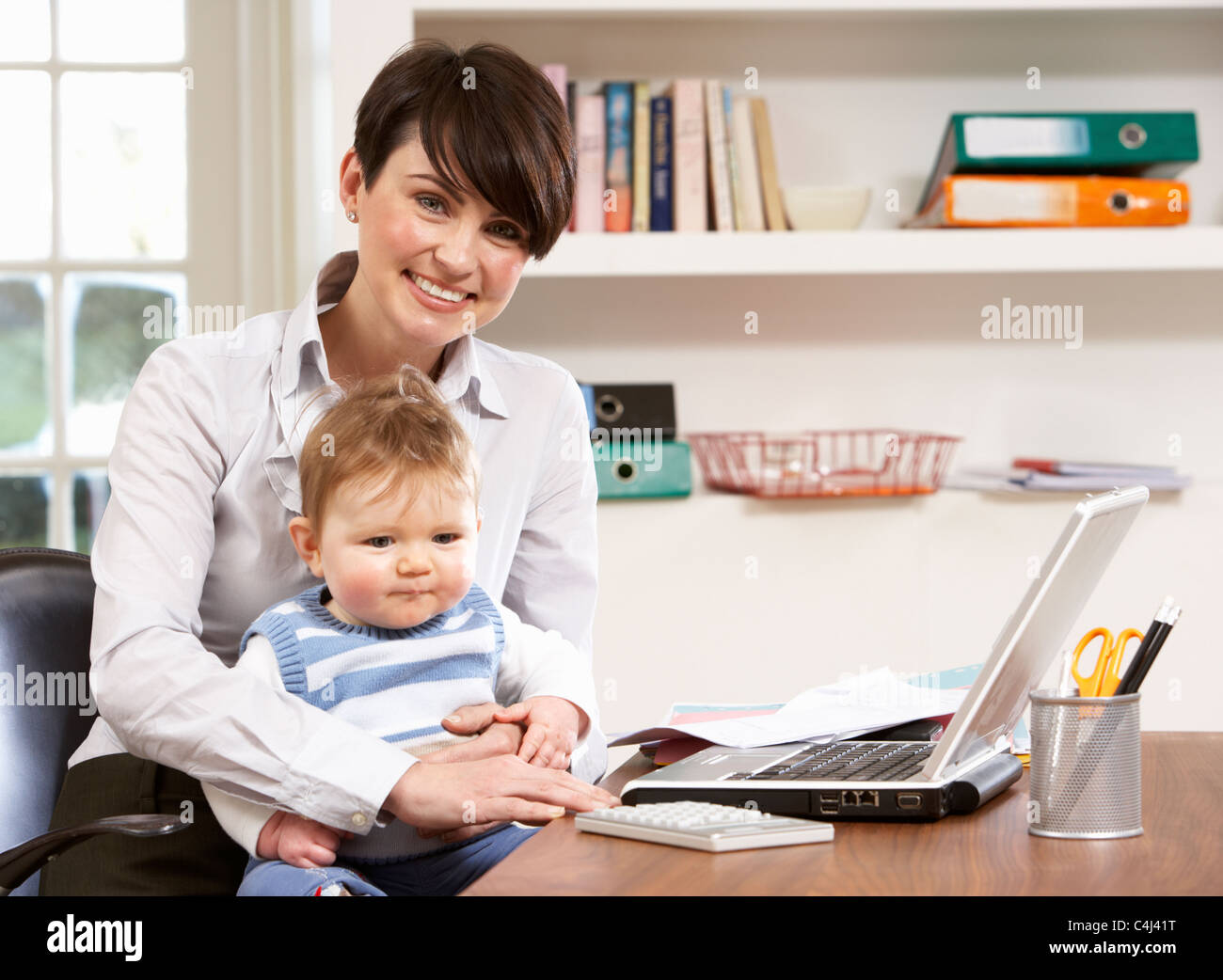 Woman With Baby Working From Home Using Laptop Stock Photo - Alamy