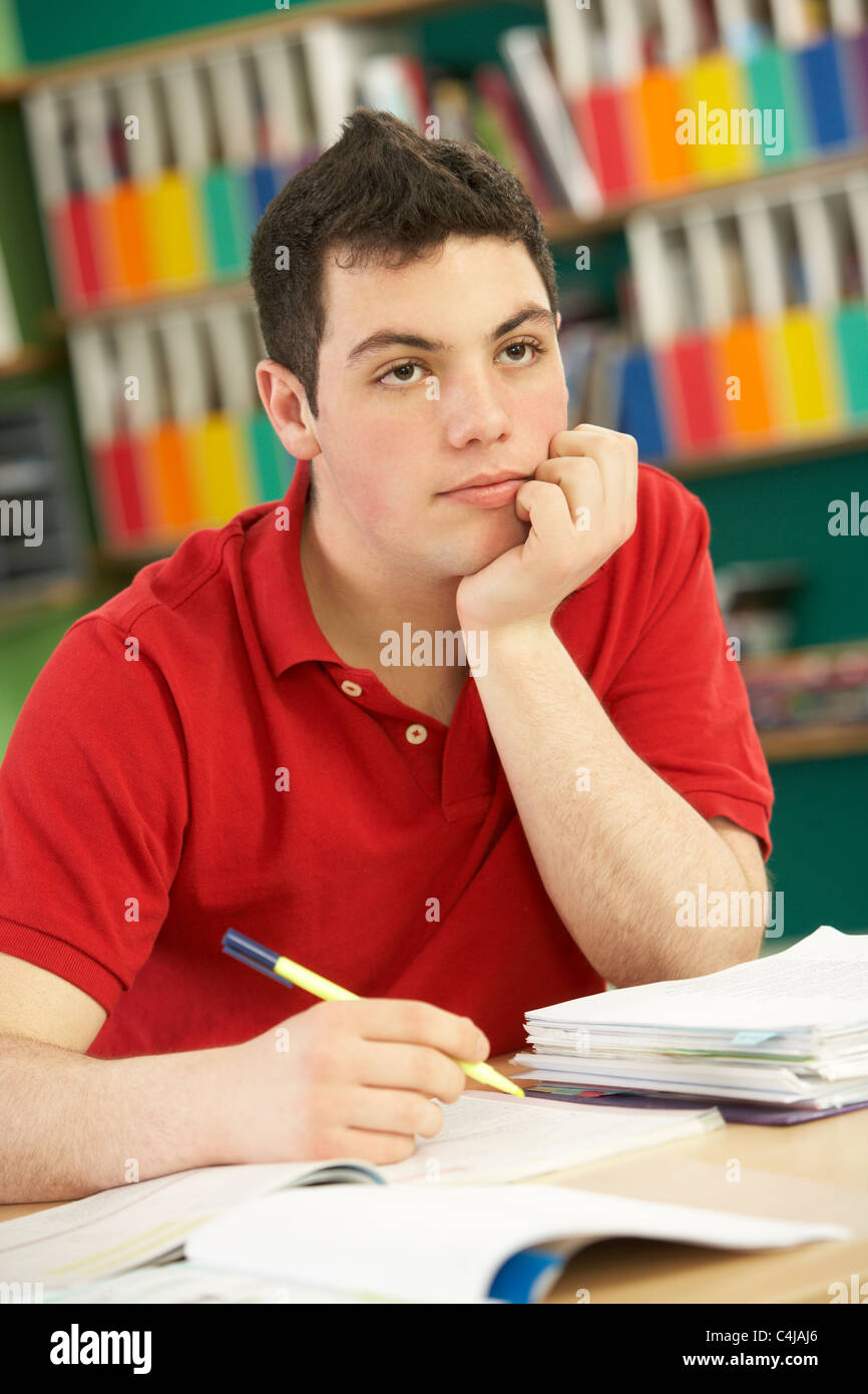 Stressed Male Teenage Student Studying In Classroom Stock Photo - Alamy