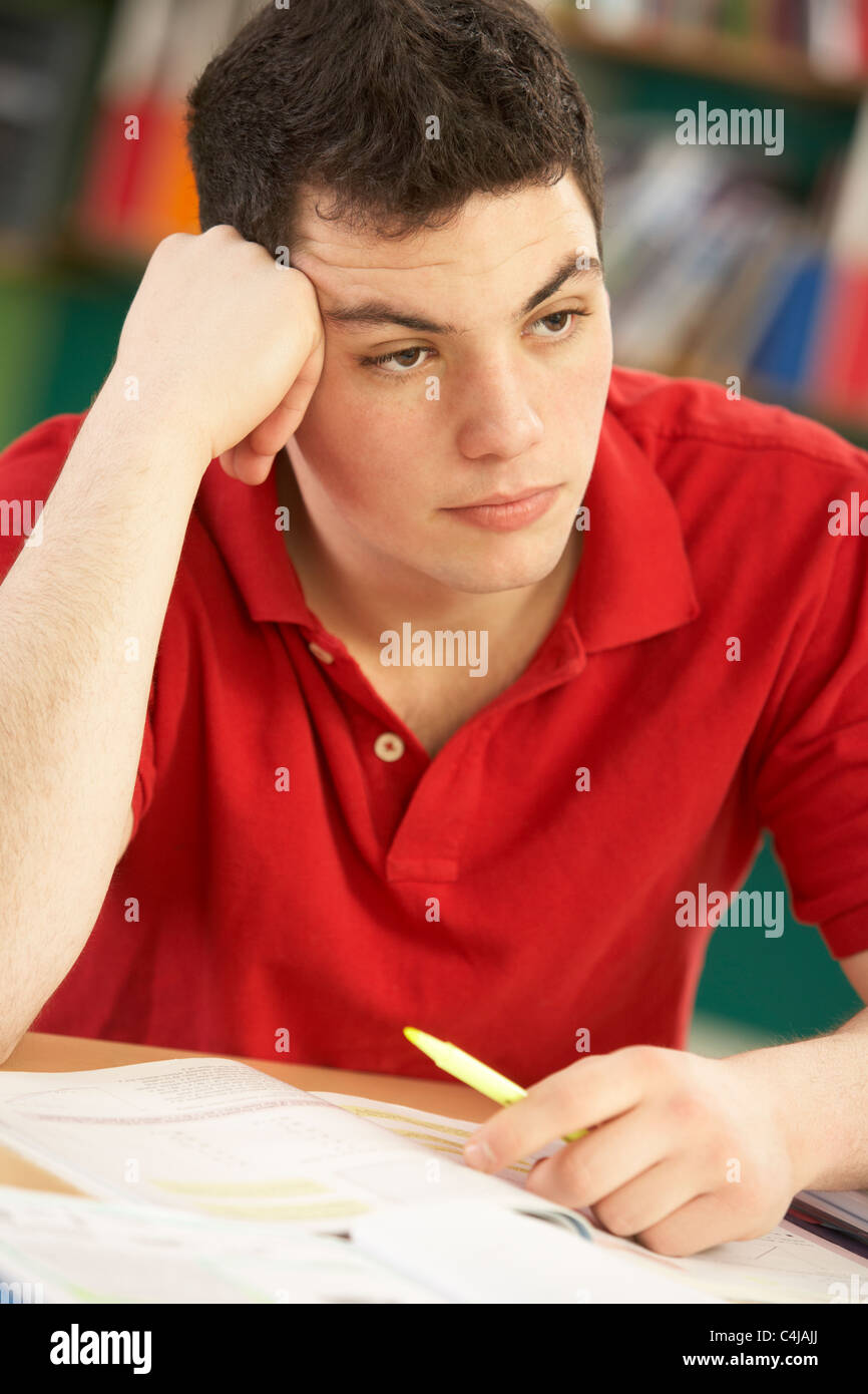 Stressed Male Teenage Student Studying In Classroom Stock Photo - Alamy