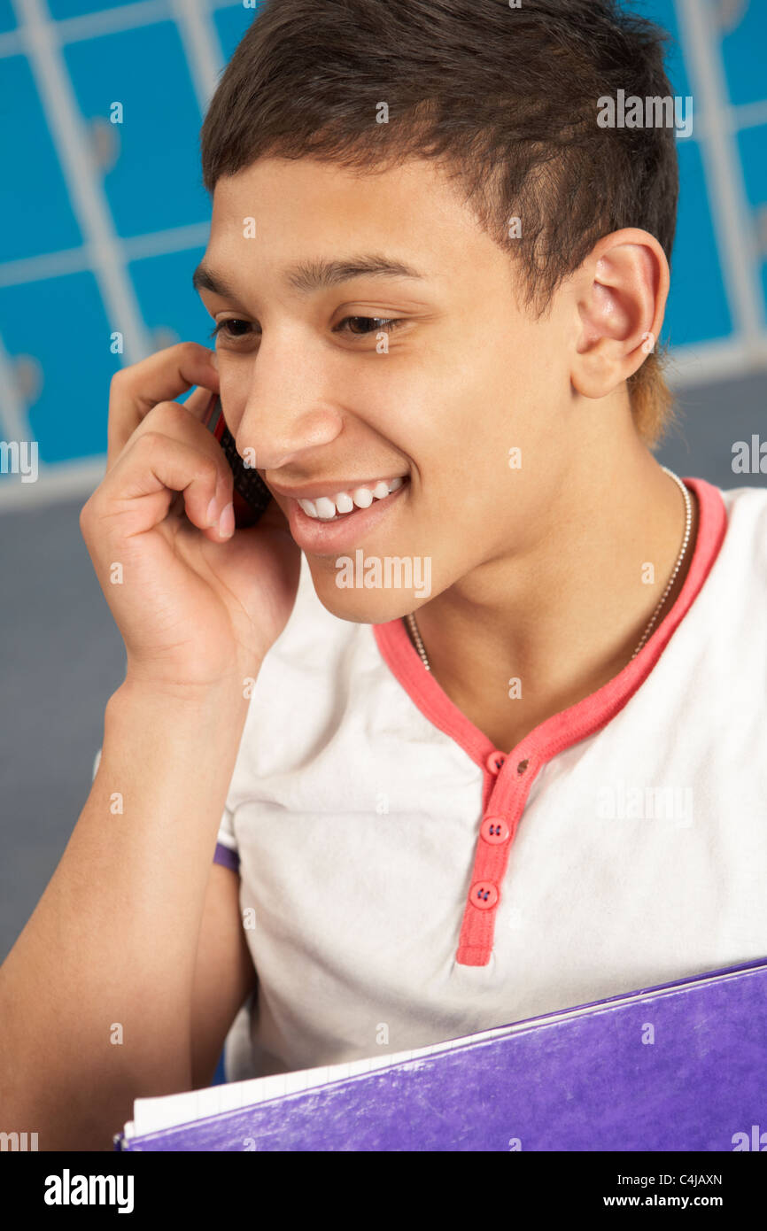 Male Teenage Student Using Mobile Phone By Lockers In School Stock ...