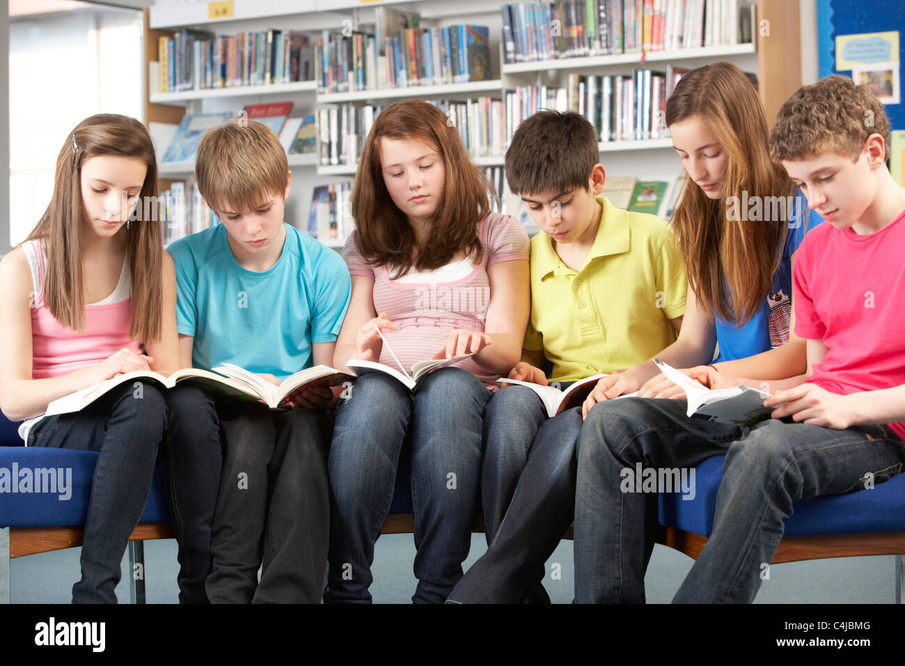 Teenage Students In Library Reading Books Stock Photo - Alamy