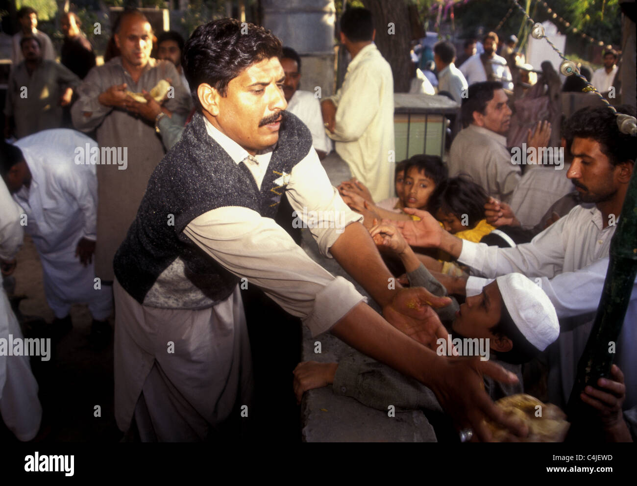 Poor Muslim men being given free food at a shrine in Pakistan Stock ...