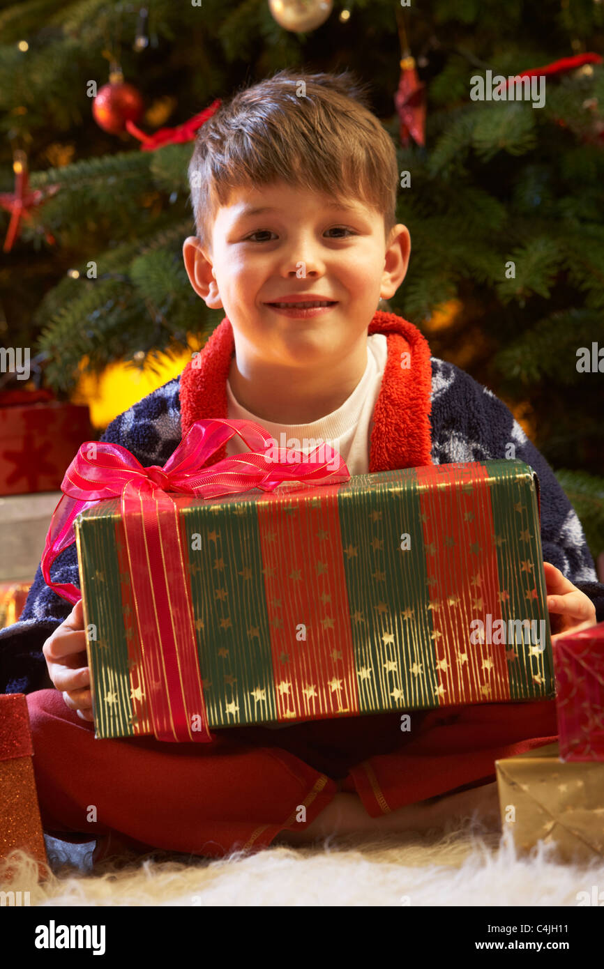 Young Boy Opening Christmas Present In Front Of Tree Stock Photo - Alamy