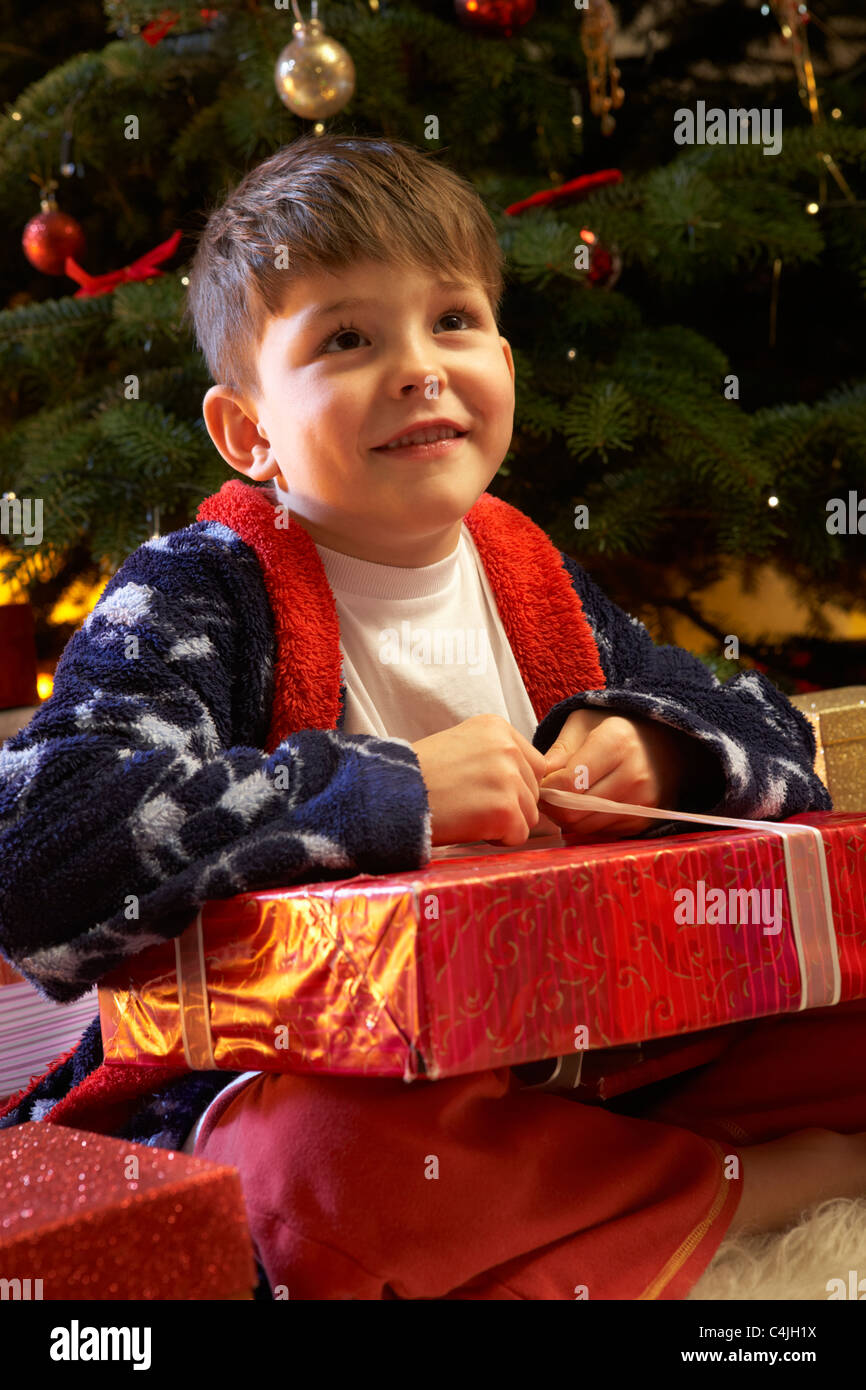 Young Boy Opening Christmas Present In Front Of Tree Stock Photo - Alamy