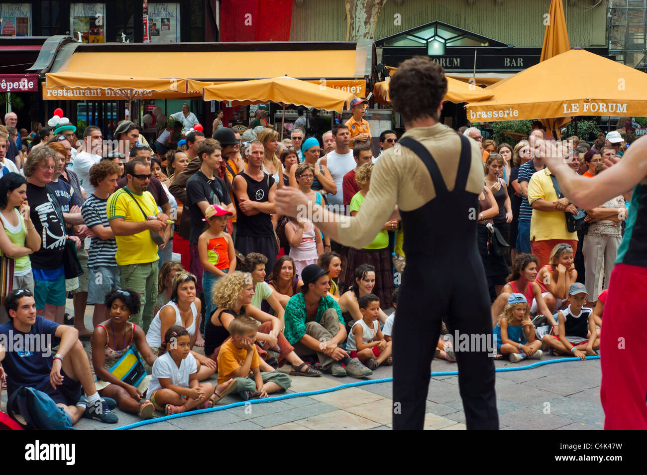 Large crowd watching street performer hi-res stock photography and ...
