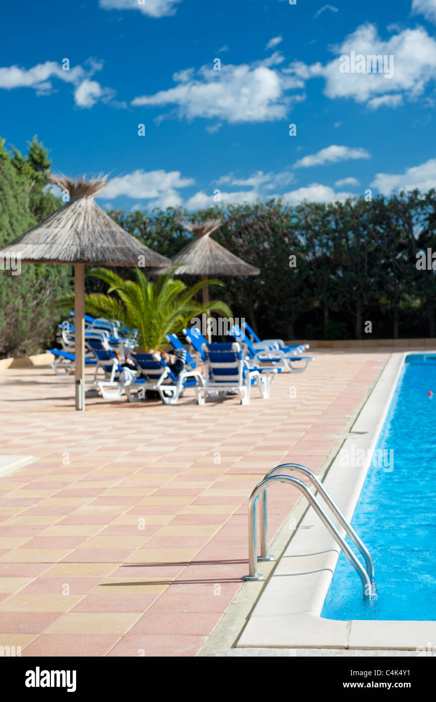 Luxury tropical swimming pool with straw parasols Stock Photo - Alamy
