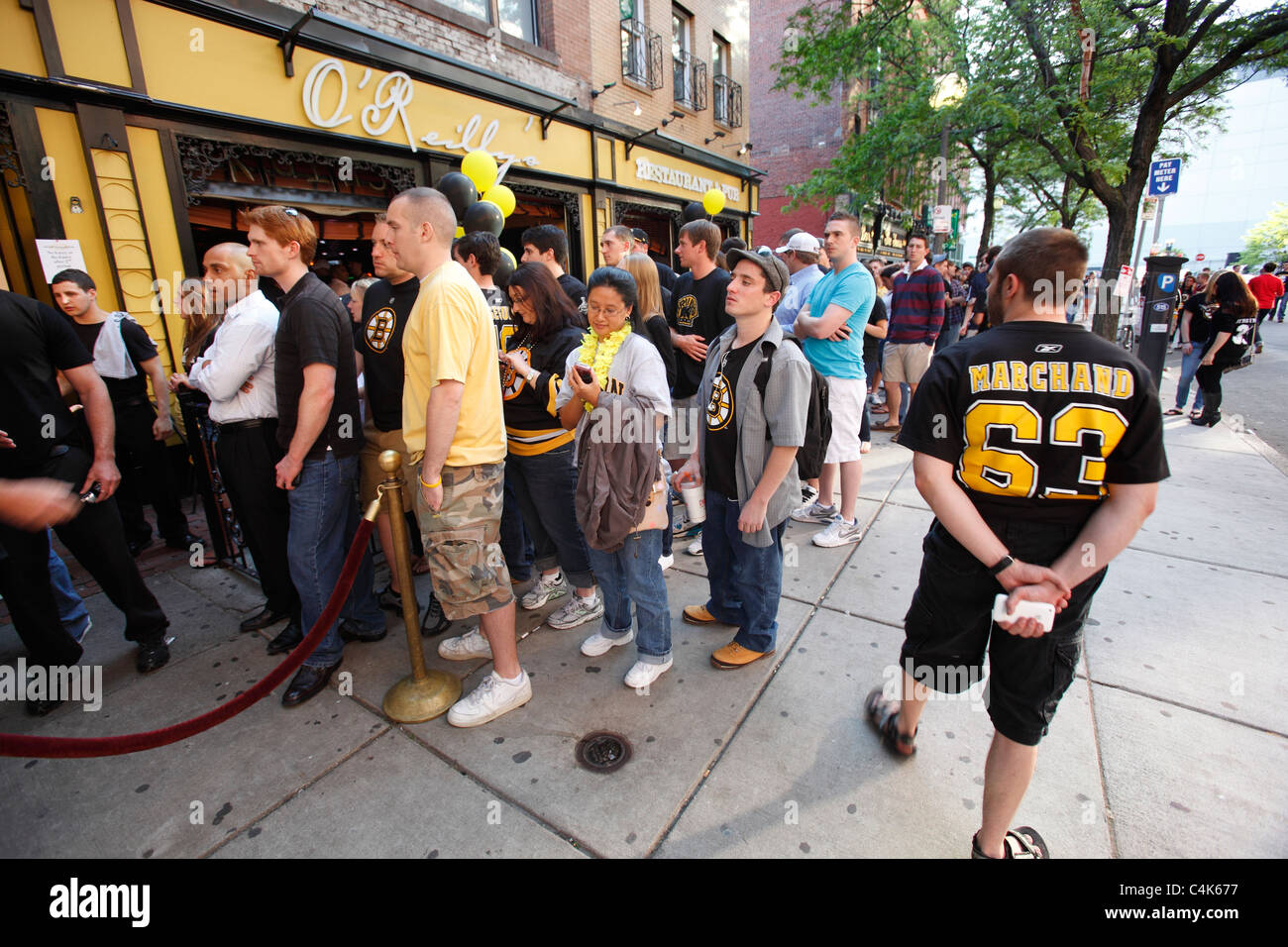 Boston Bruins hockey fans line up to enter a bar in Boston for game ...