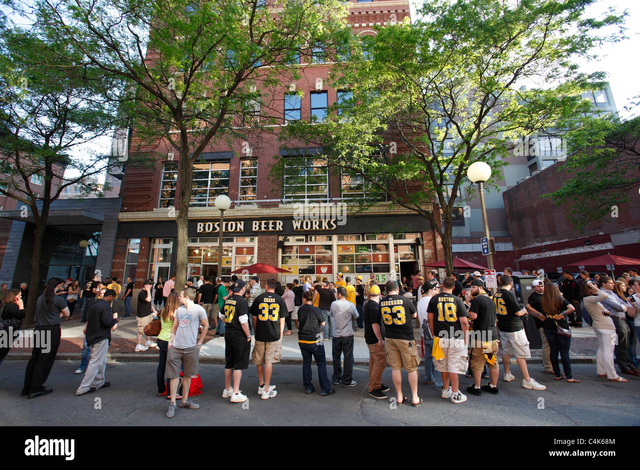 Boston Bruins hockey fans line up to enter a bar in Boston for game ...