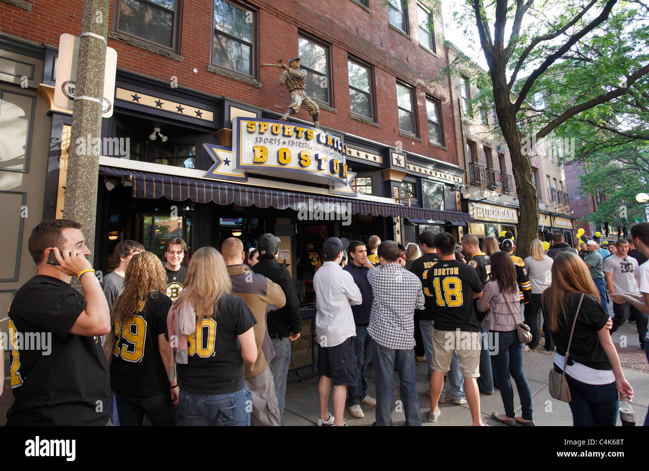 Boston Bruins hockey fans line up to enter a bar in Boston for game ...