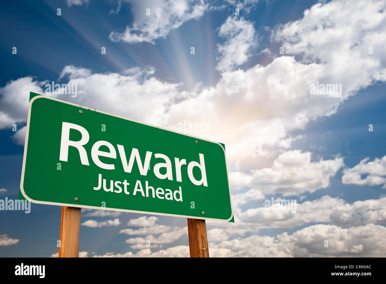 Reward Green Road Sign Against Clouds and Sunburst Stock Photo - Alamy