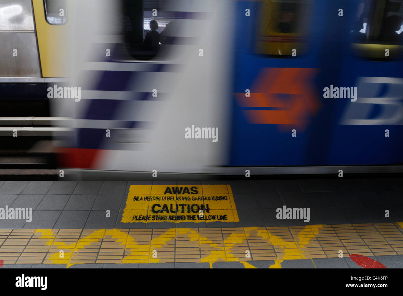 Stand behind the yellow line caution at a train platform in Kuala ...