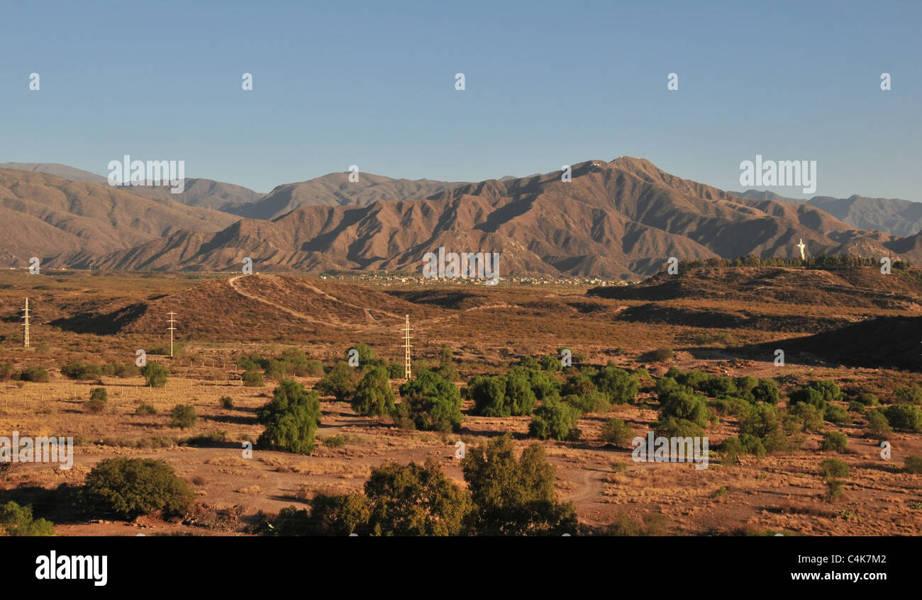 Blue sky view of gullied Andean peaks and brown arid landscape and ...