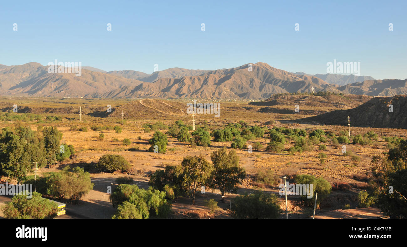 Blue sky view of gullied Andean peaks, brown arid landscape, white ...