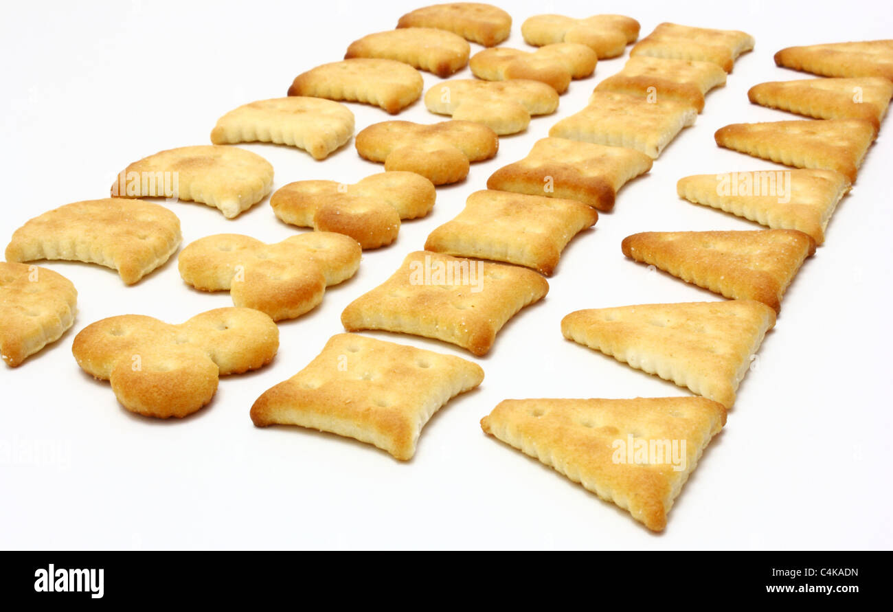 Salty crackers of the various geometrical form lie on a white ...