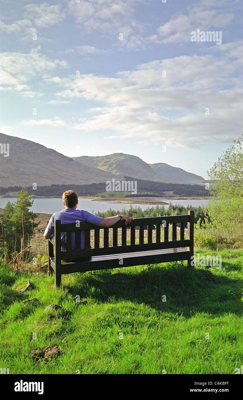 Caucasian Adult Male sitting on a bench looking Loch Dee, Galloway ...