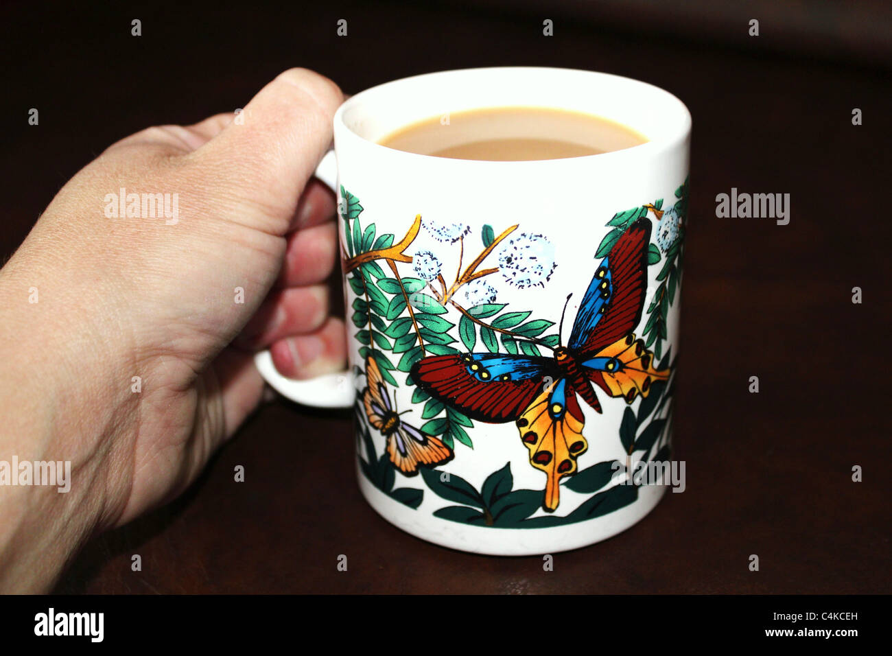 Hand passing hot warm cup of english tea Stock Photo - Alamy