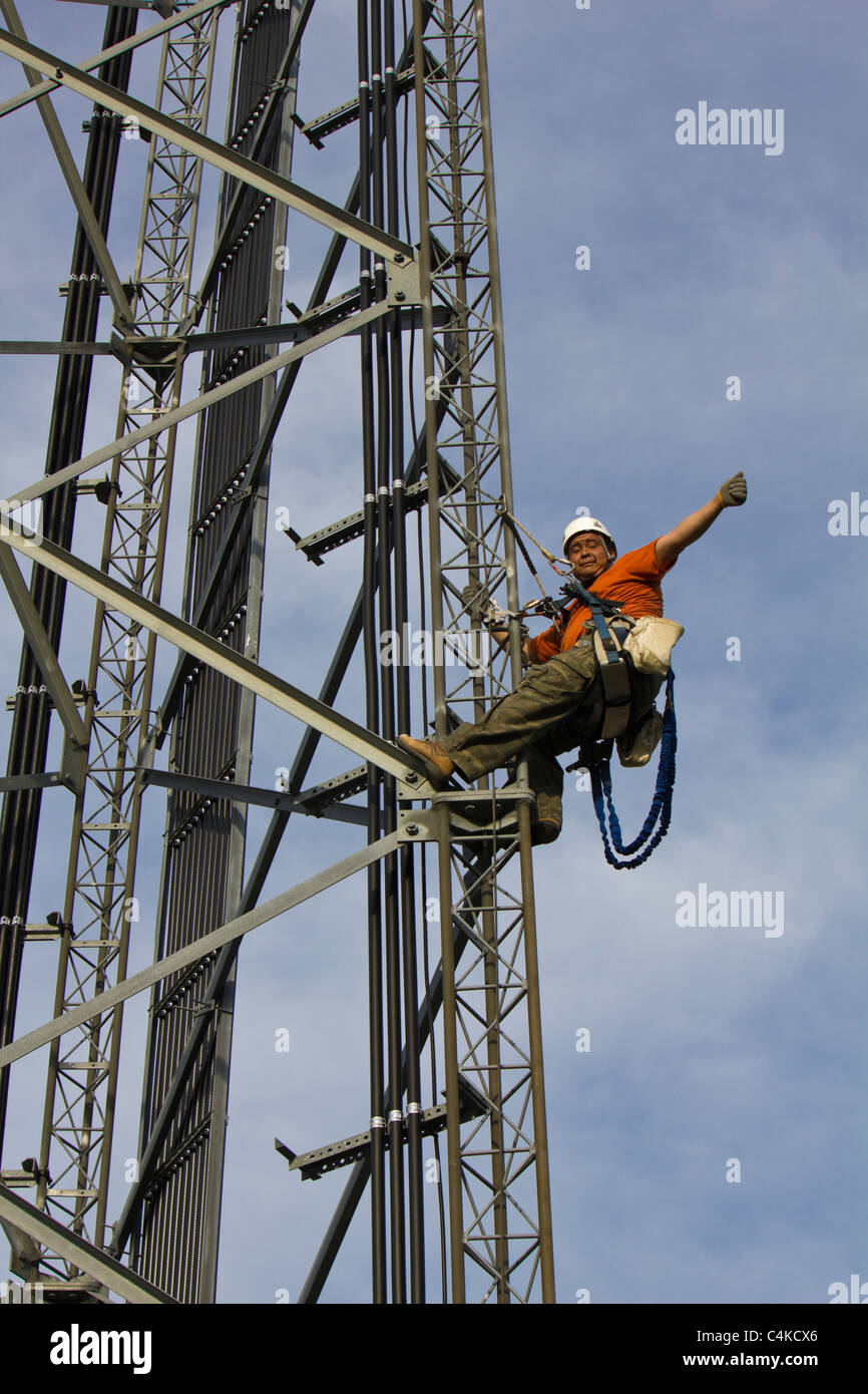 Climber giving signs while climbing 200' self support tower Stock Photo ...