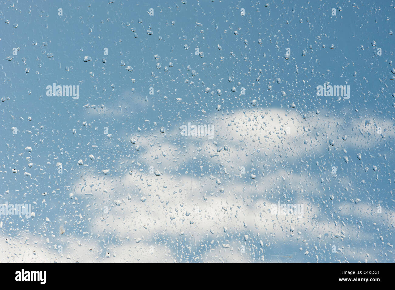 Raindrops on a window in front of a cloudy blue sky Stock Photo - Alamy