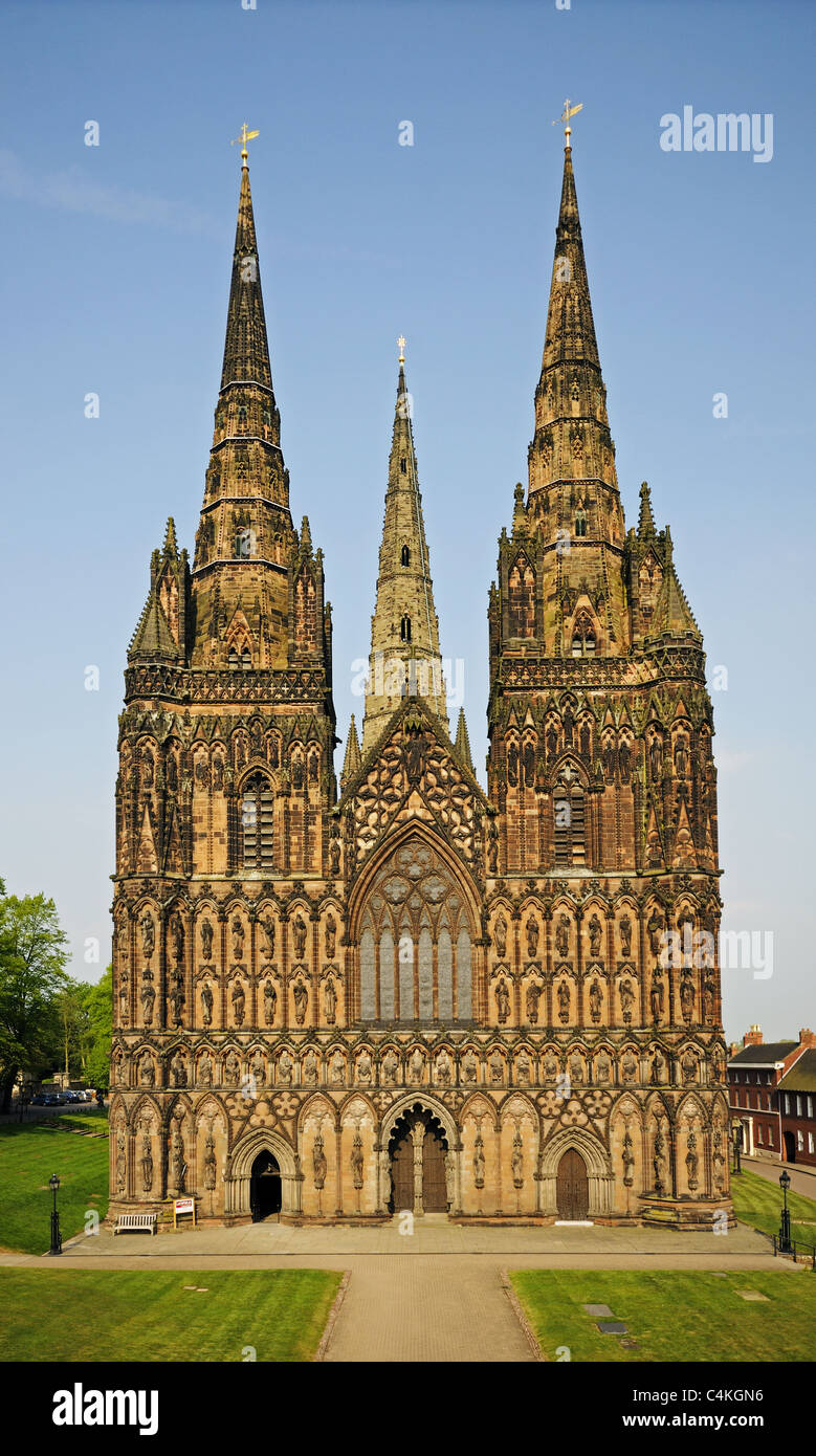 Lichfield Cathedral west front with three spires with green grass and ...