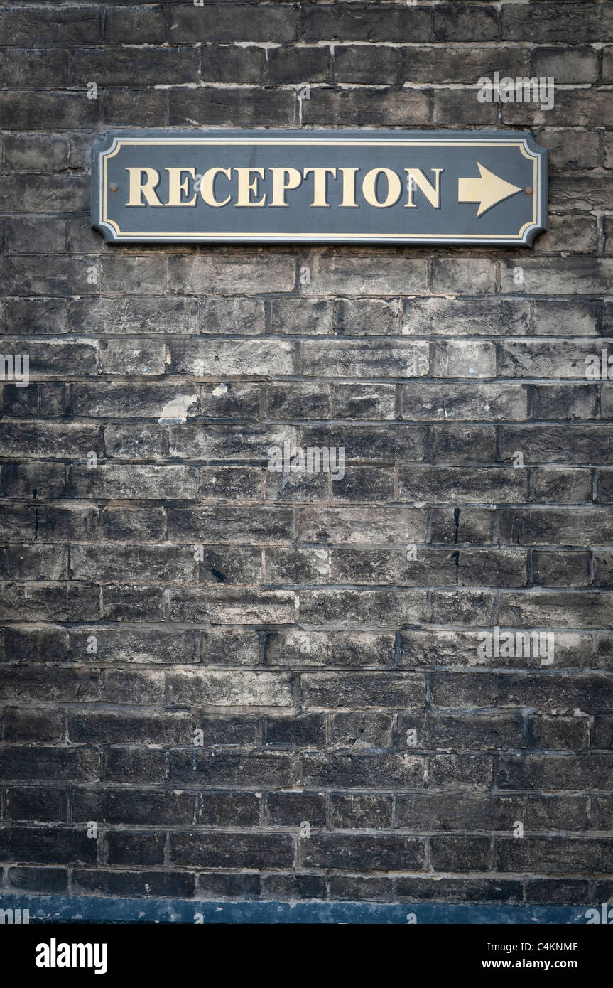 Reception sign on black brick wall Stock Photo - Alamy