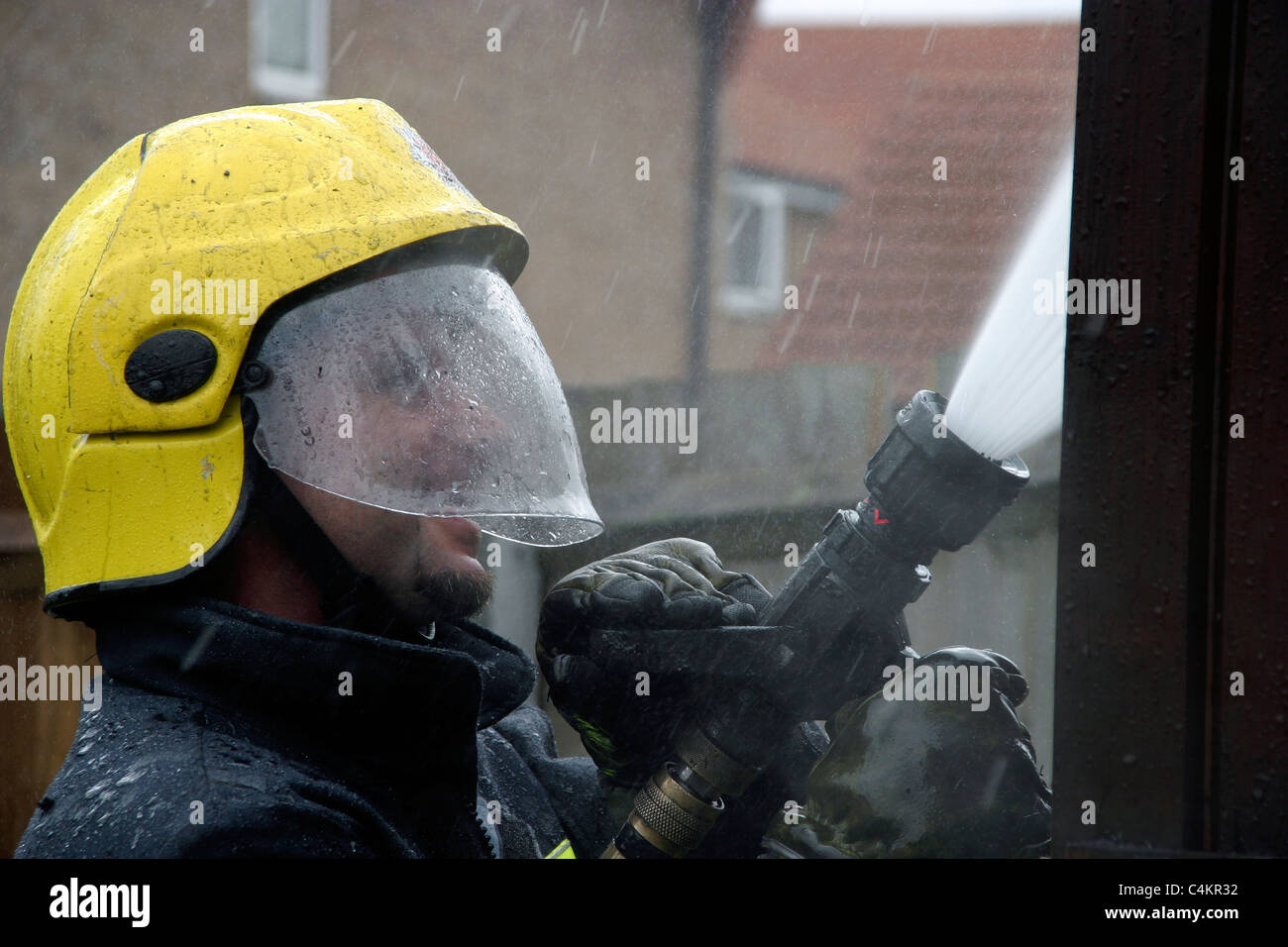 Firefighter with a hose Stock Photo - Alamy