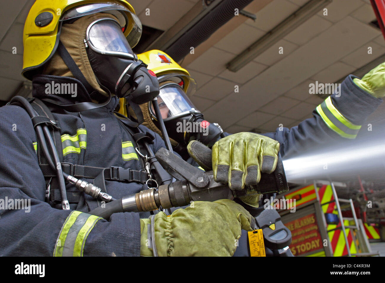 Firefighters with a hose Stock Photo - Alamy