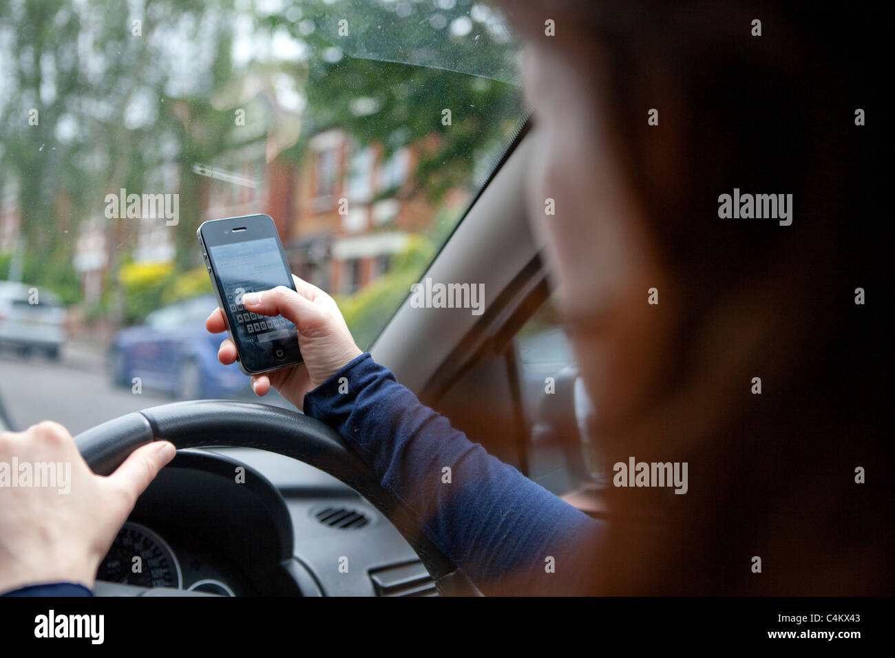 Woman texting on phone whilst driving Stock Photo - Alamy
