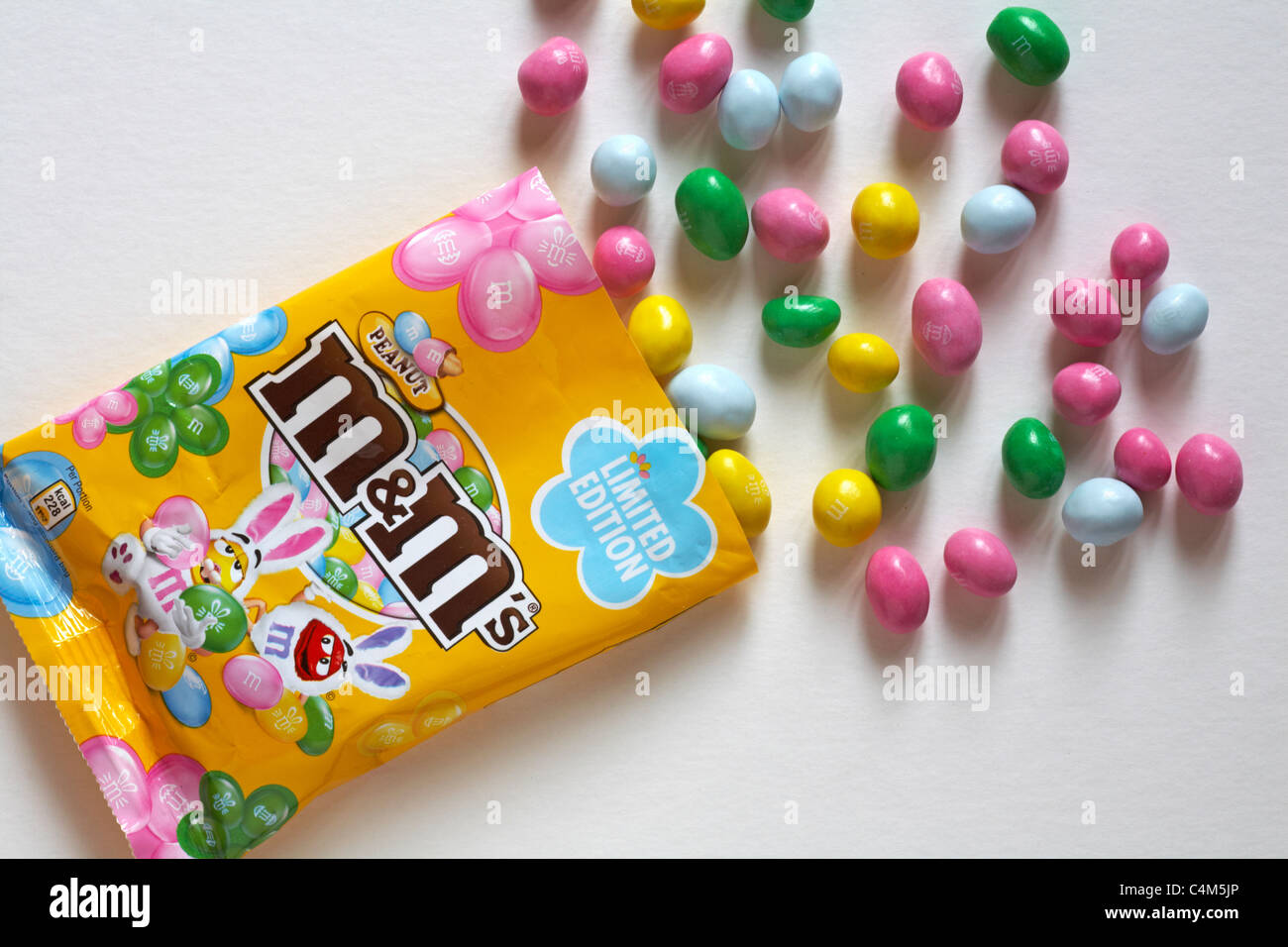 Limited Edition peanut M&Ms with contents spilled spilt on white ...