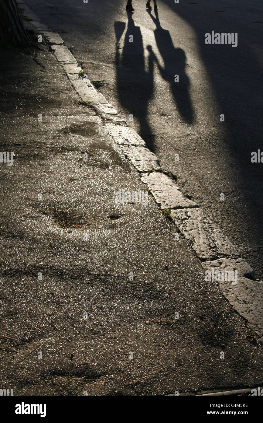 young couple holding hands shadow walking in city town Stock Photo - Alamy
