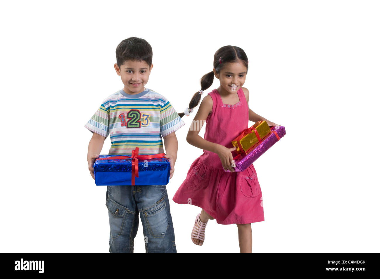 Small Indian boy and girl running holding gifts Stock Photo - Alamy