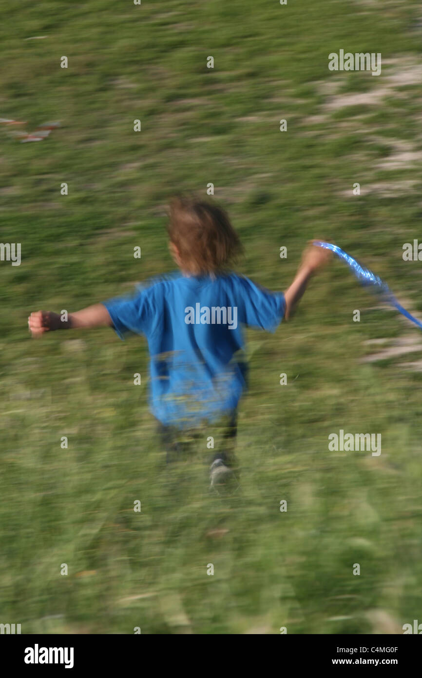 abstract boy running down hill with blue ribbon garland Stock Photo - Alamy