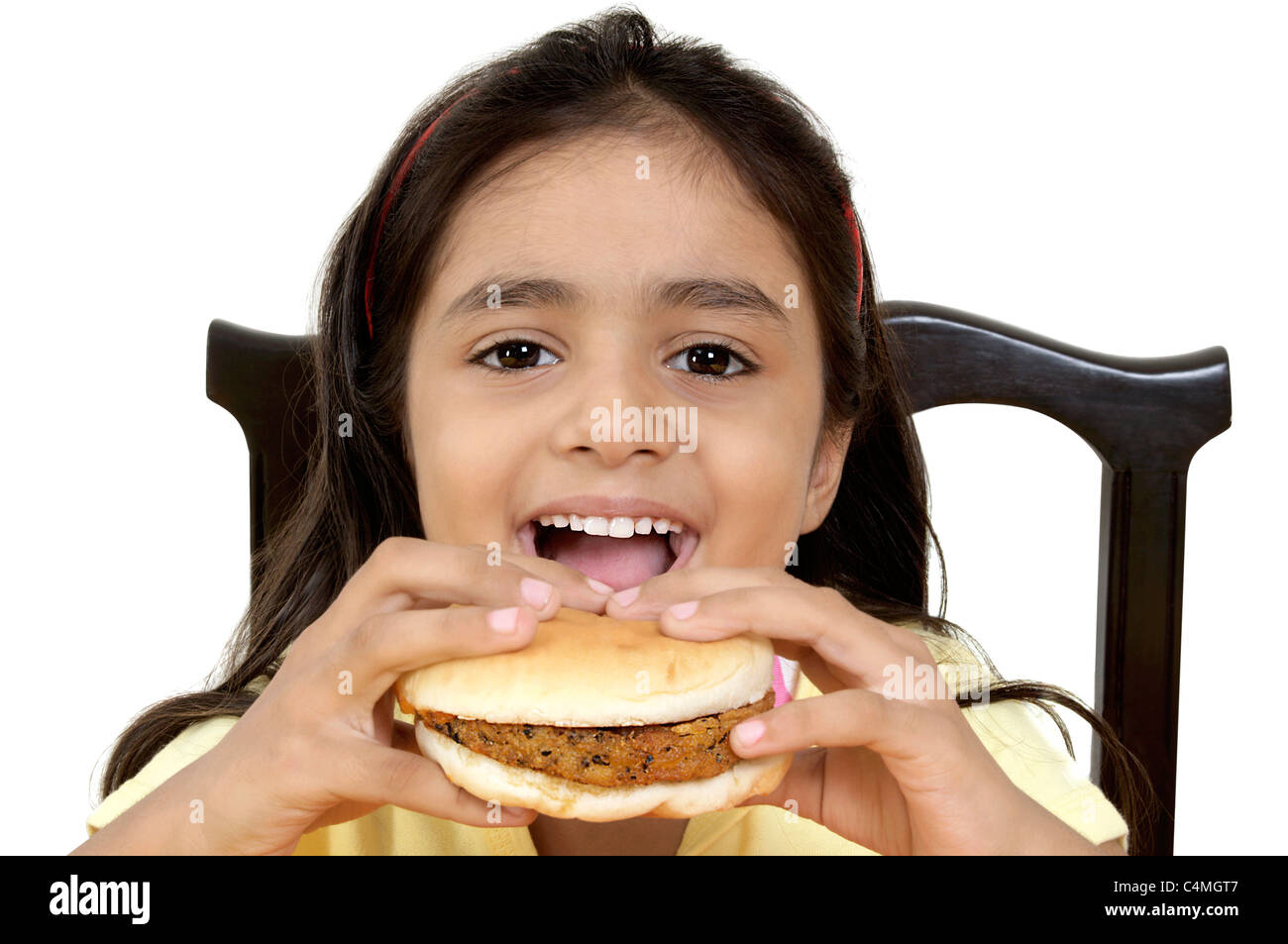 A small Indian girl enjoying while eating Stock Photo - Alamy