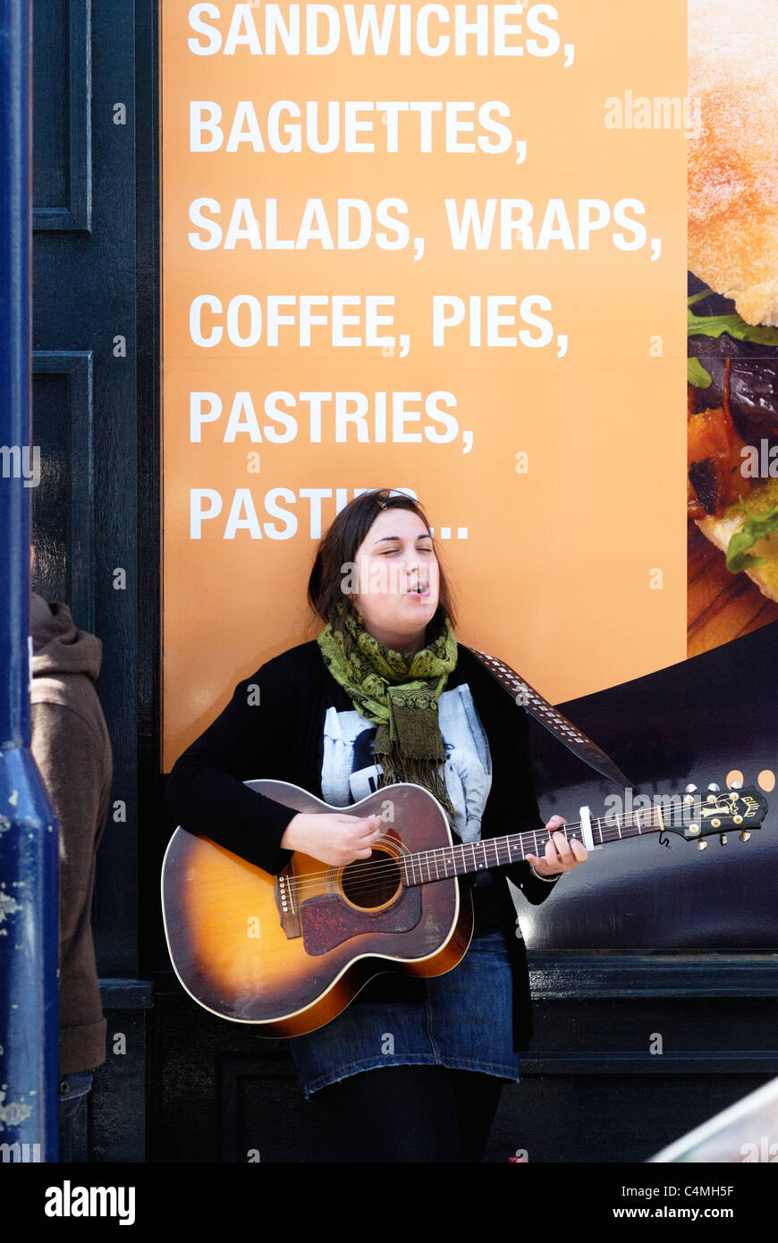 Young female singer busking with a guitar, Aberystwyth, Wales Stock ...