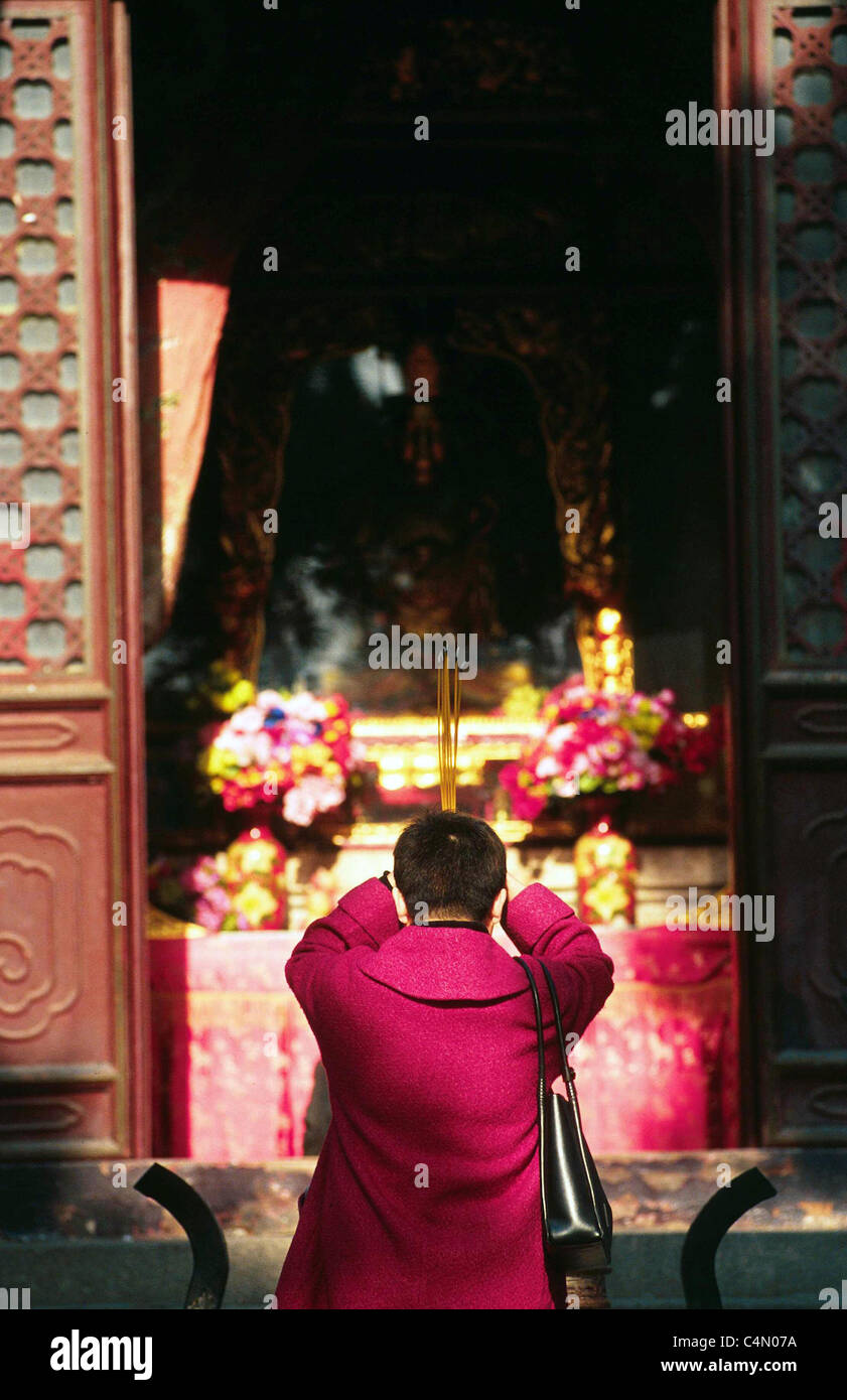 Chinese woman praying at Buddhist temple in Qingdao. China Stock Photo ...