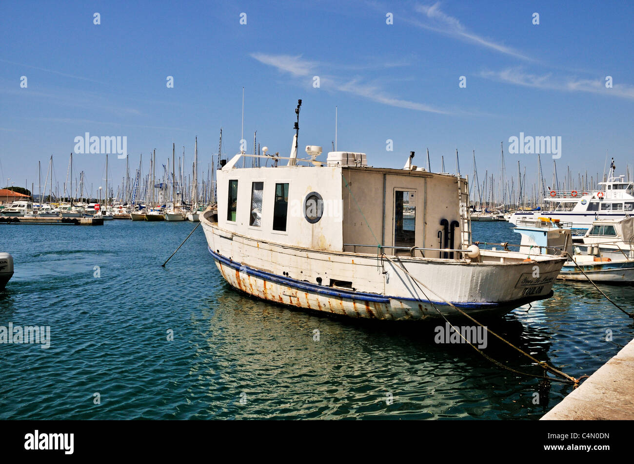 A rust stained pleasure boat moored to the quayside of Quai Stalingrad ...