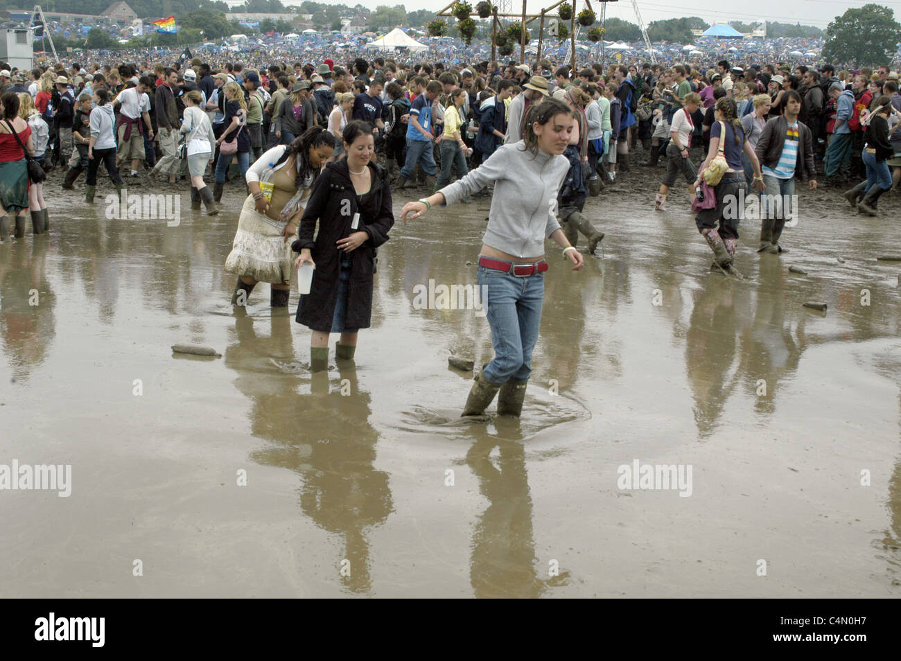 PEOPLE WALK IN THE MUD IN A FLOODED GLASTONBURY FESTIVAL, SOMERSET ...