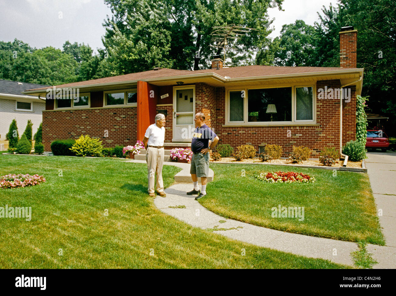 Retired homeowner and neighbor in front of modest American house Stock ...