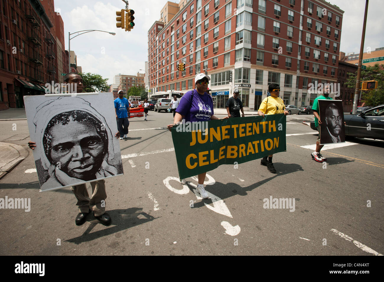 Participants march in the Juneteenth celebration parade through the ...