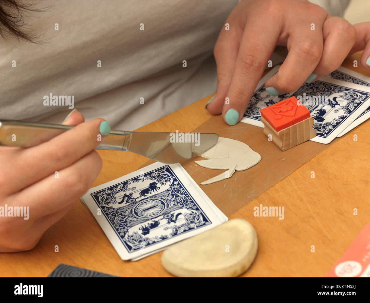 Teenage Girl Making Jewellery Cutting Out Shapes In Silver Clay Using A ...