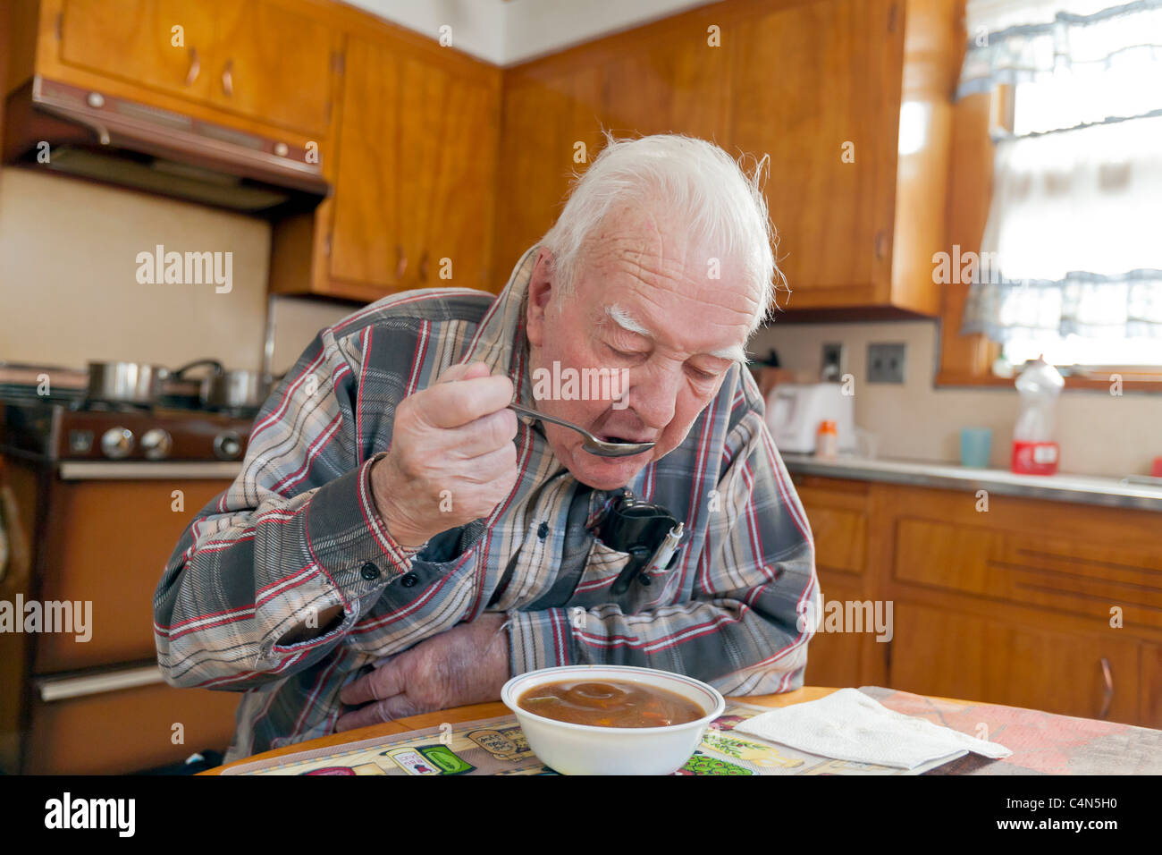 A retired elderly Senior Man in his home eating soup Stock Photo - Alamy
